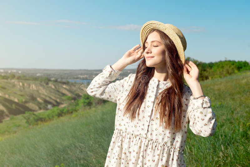 Beautiful Sensual Brunette In Dress And Hat Standing With Eyes Closed