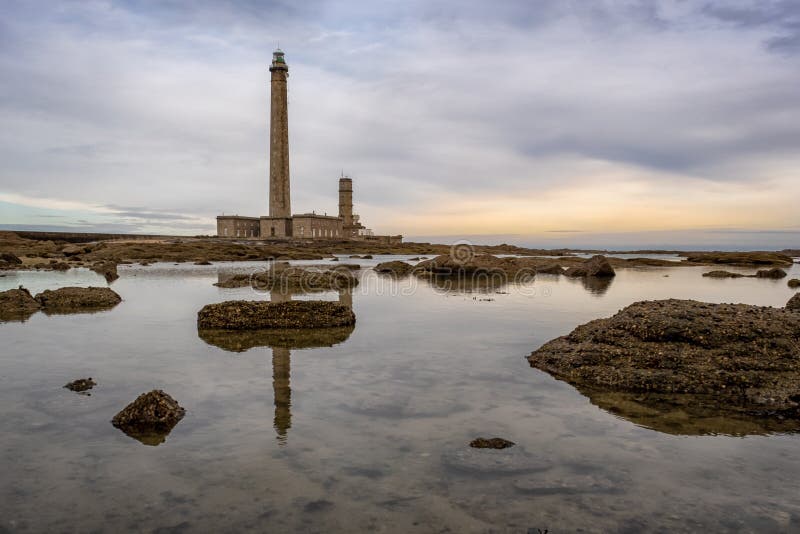 Beautiful Shot of a Lighthouse Reflecting in the Ocean during Sunset ...