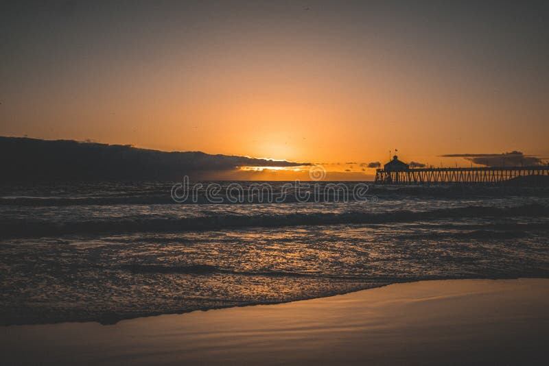 Beautiful Shot of the Sandy Shore of an Ocean with the Pier Visible in ...
