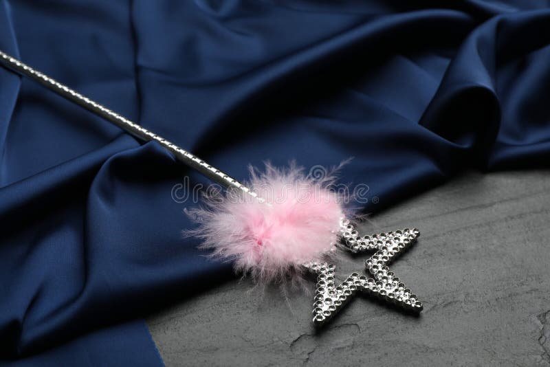 Beautiful Silver Magic Wand with Feather and Blue Fabric on Black Table ...