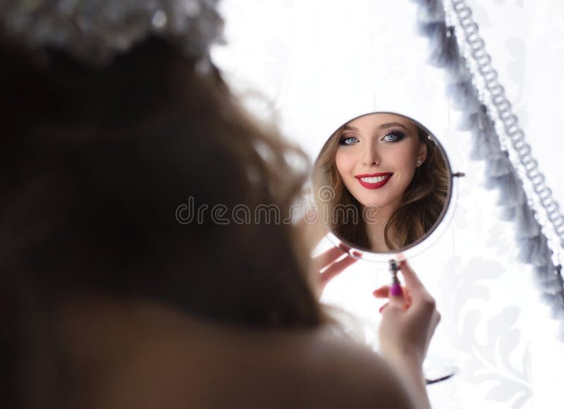 Beautiful Smiling Bride with Wedding Makeup in the Reflection of a ...