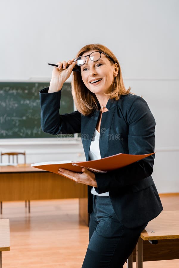 Beautiful Smiling Female Teacher in Formal Wear and Glasses Holding ... Beautiful Smiling Female Teacher in Formal Wear and Glasses Holding ...