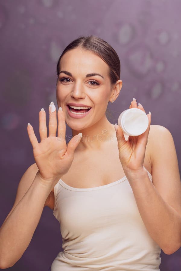 Beautiful Smiling Woman Applying Cosmetic Cream Treatment On Her Stock