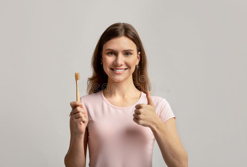 Beautiful Smiling Woman Holding Natural Wooden Bamboo Toothbrush and ... Beautiful Smiling Woman Holding Natural Wooden Bamboo Toothbrush and ...