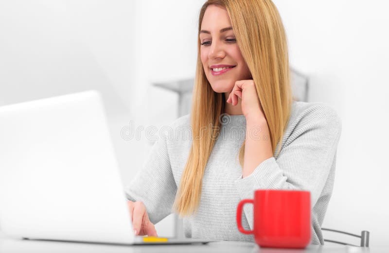 Beautiful Smiling Woman Working at a Laptop at Home or in the Office ...