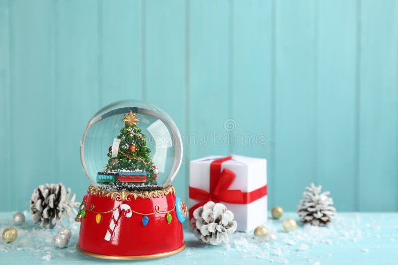 Beautiful Snow Globe, Gift Box and Christmas Decor on Light Blue Table ...