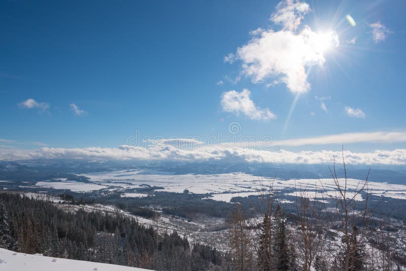 Beautiful Sun Shining Though a Cloud Over Valley Covered in Snow Stock ...