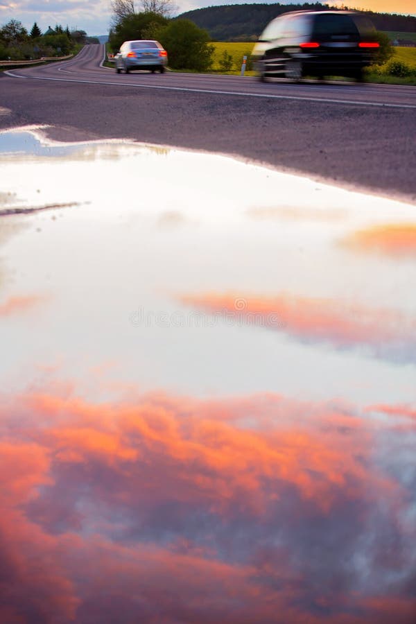 Beautiful Sunset Clouds and Tree, Reflecting in Water Puddle Stock ...