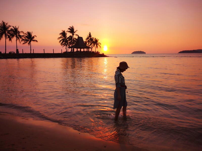 Beautiful Sunset and a Lady Playing with the Water on the Shore. Stock ...