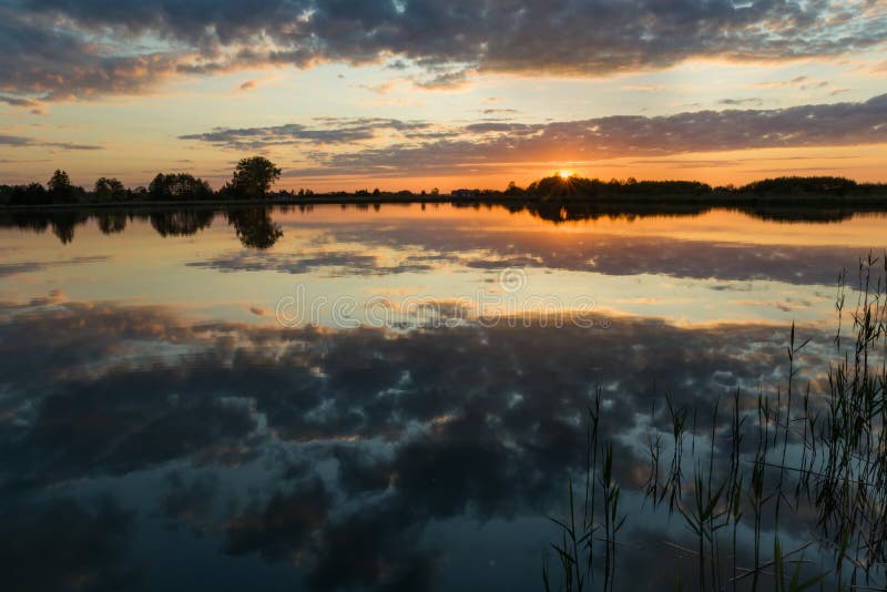 Beautiful Sunset Over a Calm Lake and Reflection of Clouds in the Water ...