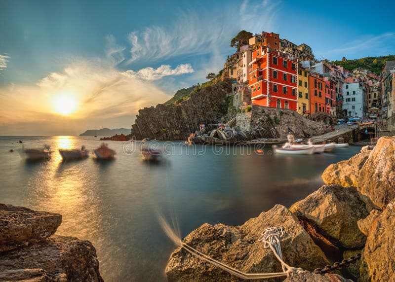 Beautiful Sunset Over a Colorful Village on a Cliff with Boats in the ... Beautiful Sunset Over a Colorful Village on a Cliff with Boats in the ...