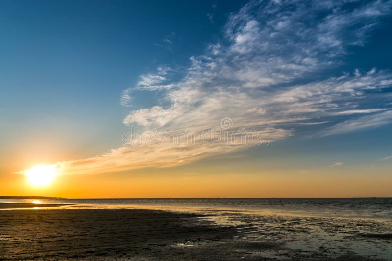 Beautiful Sunset Over the Sea Shore with Clouds Reaching the Horizon ...