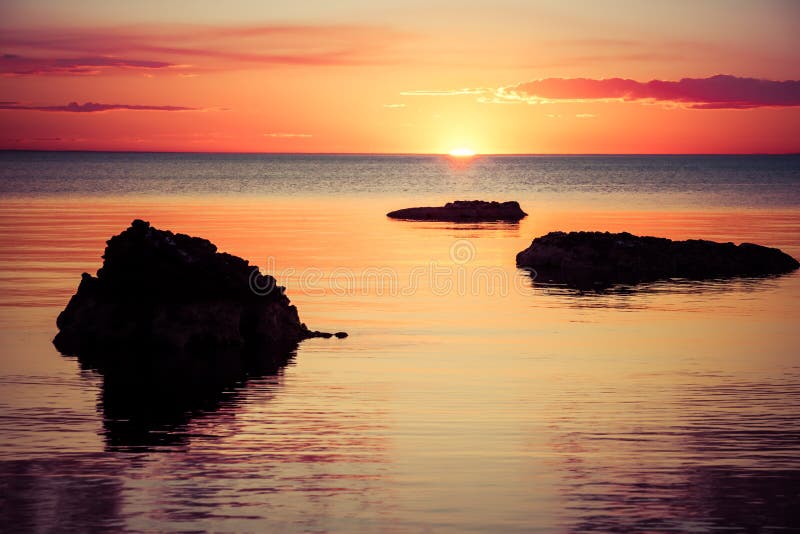 Beautiful Sunset Over Water, with Rock Silhouettes. Stock Photo - Image ...