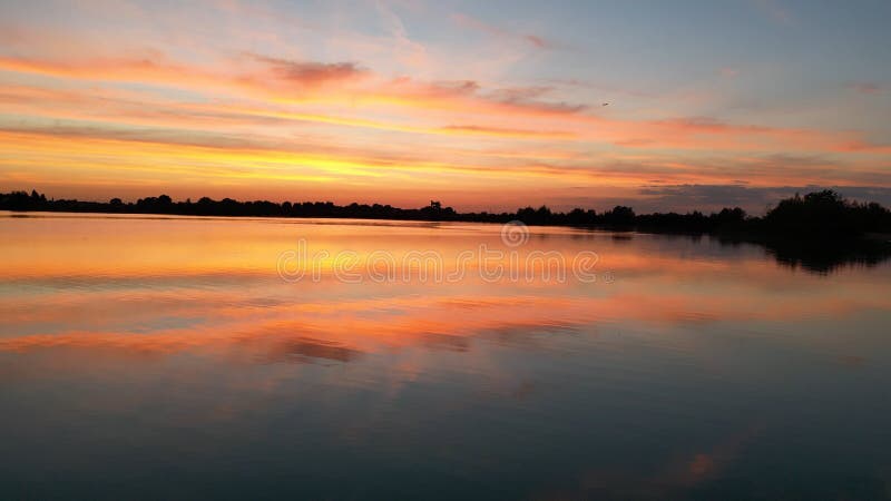 The Sunset Reflecting Off the Calm Water of a Lake As Seen from Behind ...