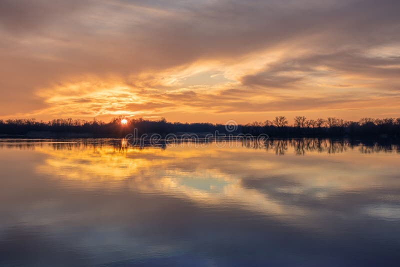 Beautiful Sunset with Reflection of Clouds on the Surface of the Smooth ...