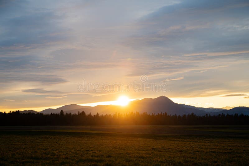 Beautiful Sunset with the Sun Setting Behind the Hills Stock Photo ...
