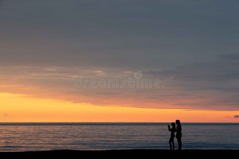 At a Beautiful Sunset Two People on the Shore Stock Photo - Image of ...