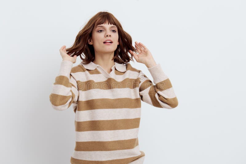 A Beautiful Sweet Attractive Woman Stands In A Striped Sweater On A