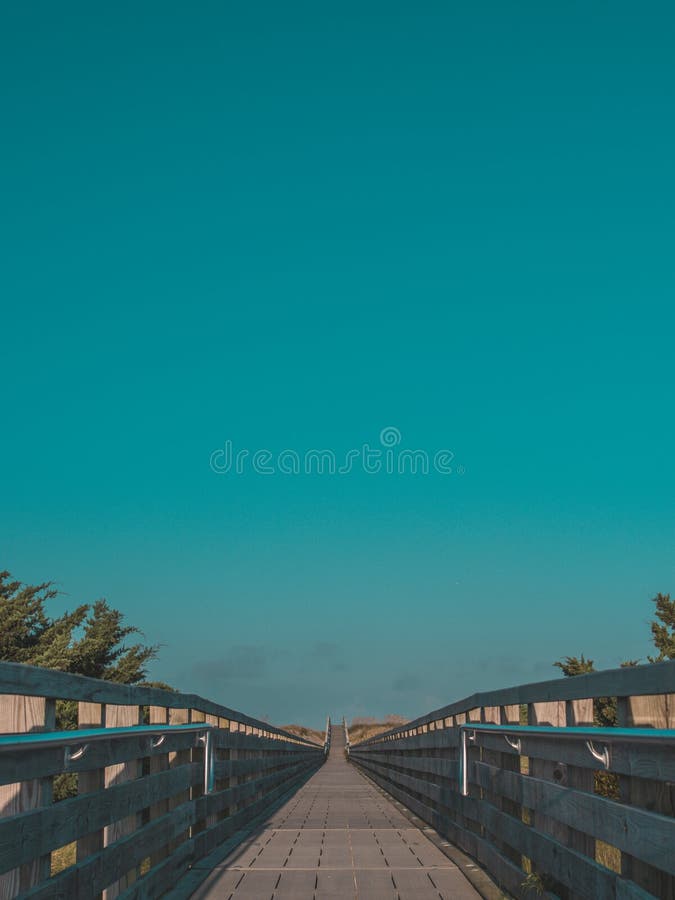 Beautiful Symmetric Shot of a Beachfront Bridge with Clear Blue Sky ...