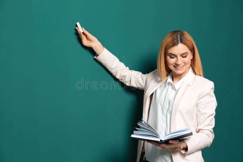 Beautiful Teacher with Book Pointing at Chalkboard Stock Photo - Image ...