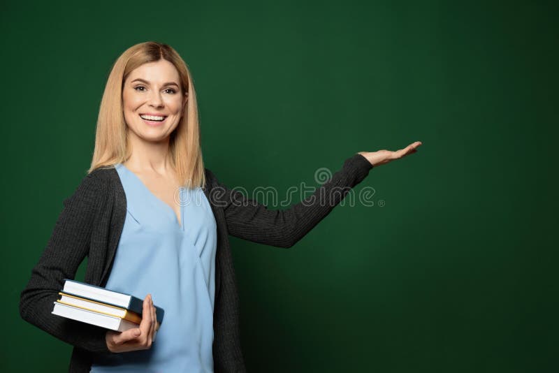 Beautiful Teacher with Book Pointing at Chalkboard Stock Photo - Image ...