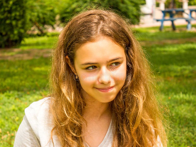 Beautiful Teen Girl with Long Hair Smiling in the Park on the Green ... Beautiful Teen Girl with Long Hair Smiling in the Park on the Green ...