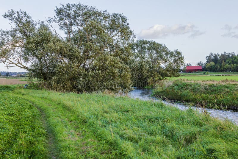 Beautiful View of Landscape with River Flowing through Fields Against ...