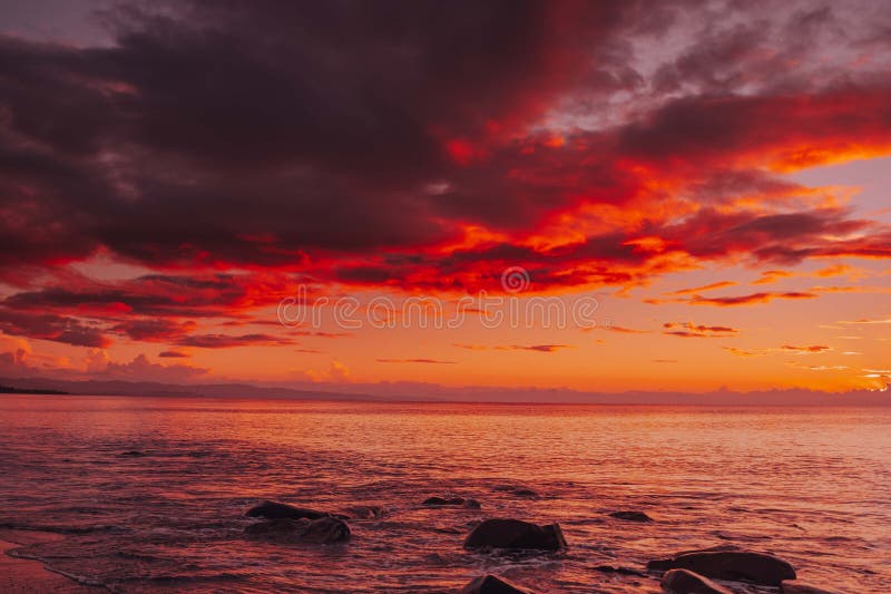 Beautiful View of a Red Sunset with Dense Clouds Floating Over the Calm ...