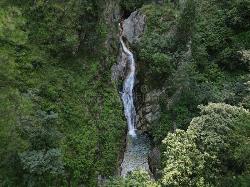 Beautiful Waterfall Flowing Down the Rocks Surrounded by Lush Trees ...