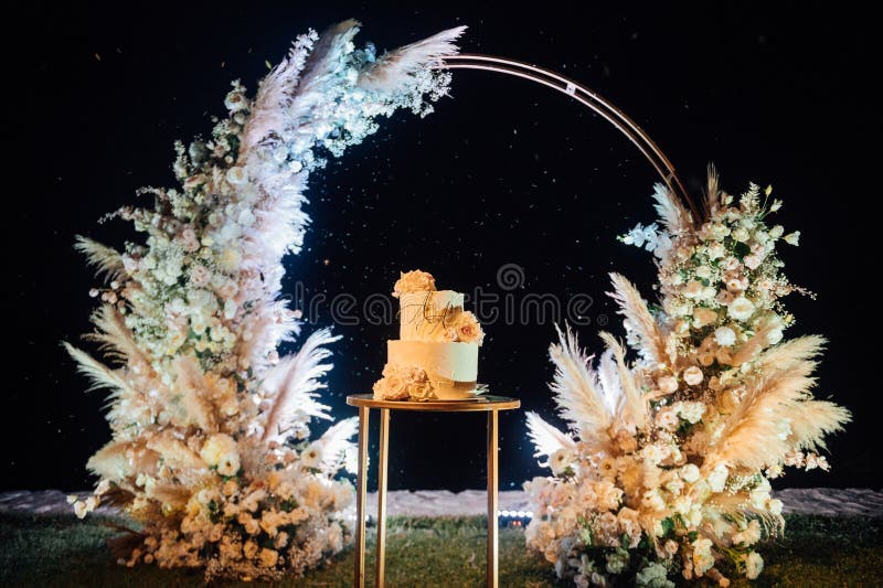 Beautiful Wedding Cake with Flowers and a Large Wedding Arch. Stock ...