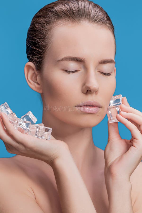 Beautiful Woman Applying Ice Cube Treatment on Blue Background Stock ...