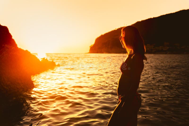 Beautiful Woman In Bikini Looking At Amazing Sunset By The Sea Stock