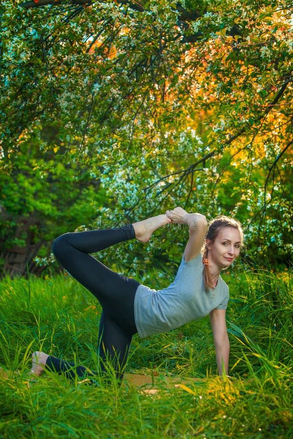 Beautiful Woman Doing Yoga Outdoors on Green Grass Stock Image - Image ...