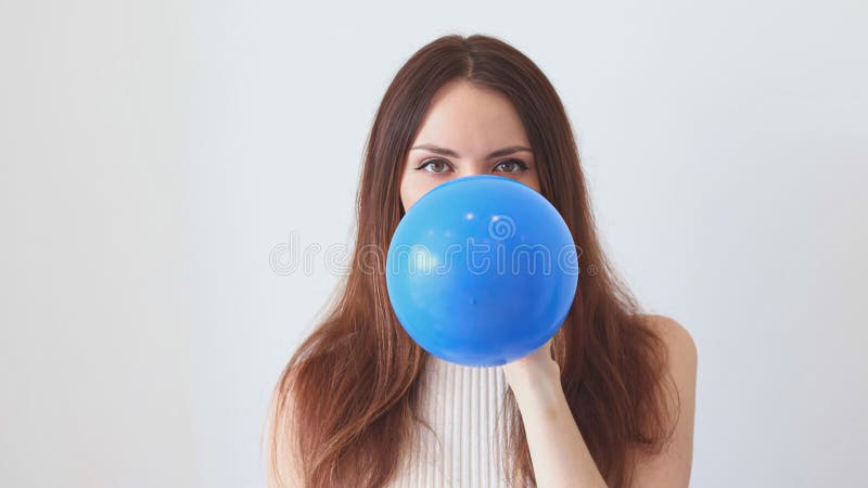 A Beautiful Woman Inflates a Blue Balloon. Stock Image - Image of ...