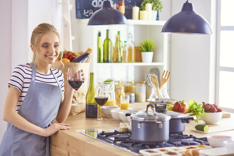 Beautiful Woman in Kitchen is Drinking Red Wine Stock Photo - Image of ...