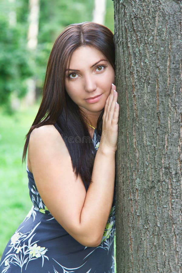 Beautiful Woman Leaning Back Against the Tr Stock Photo - Image of ...