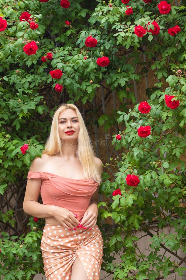 Beautiful Woman With Long Blonde Hair And Red Lips Wearing Pink Clothes