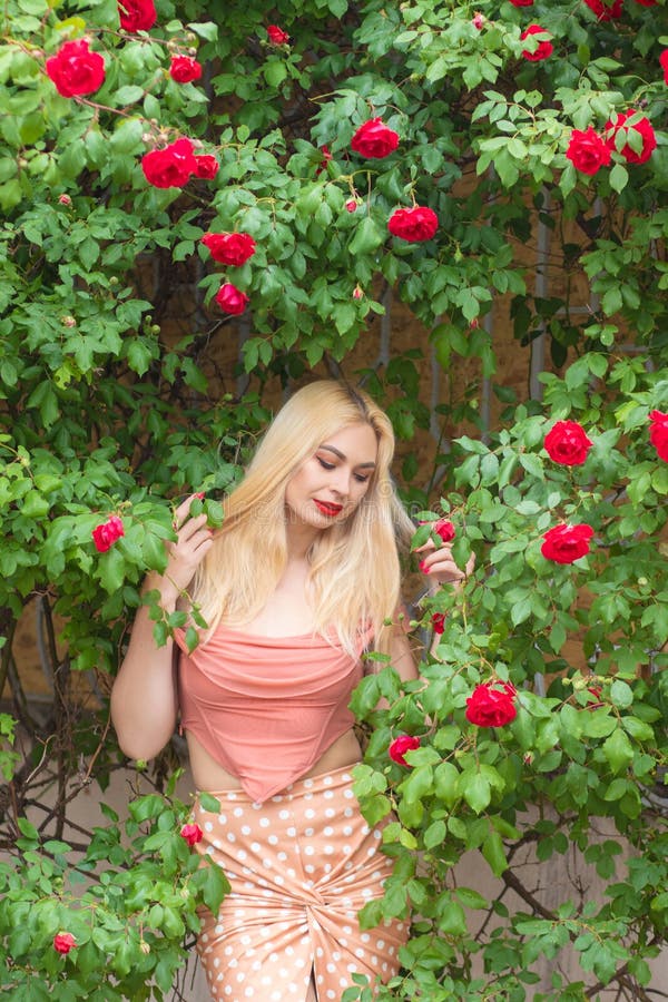 Beautiful Woman With Long Blonde Hair And Red Lips Wearing Pink Clothes