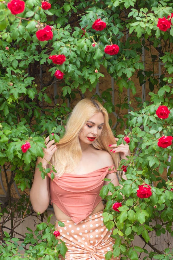 Beautiful Woman With Long Blonde Hair And Red Lips Wearing Pink Clothes