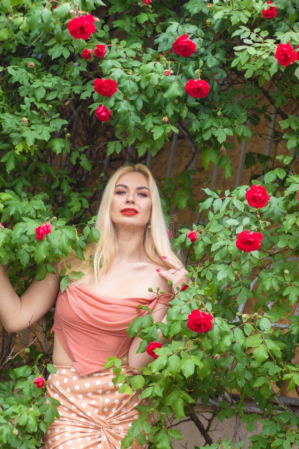 Beautiful Woman With Long Blonde Hair And Red Lips Wearing Pink Clothes