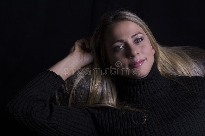Beautiful Woman Portrait In Low Light Sitting On Brown Leather Sofa