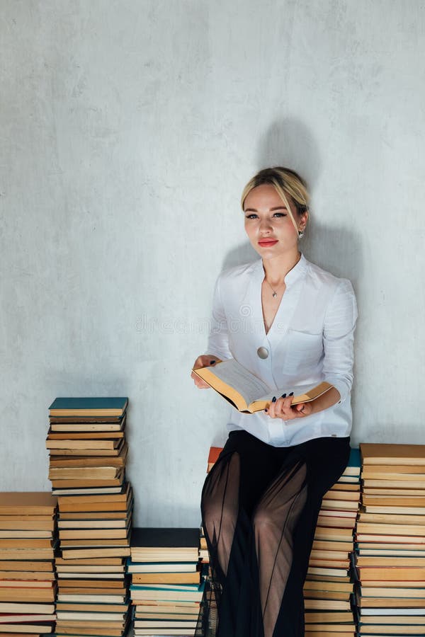 Beautiful Woman Reading Book and Stacks of Books in Library Stock Photo ...