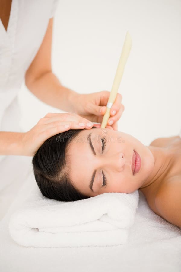 Beautiful Woman Receiving Ear Candle Treatment At Spa Center Stock