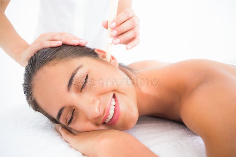 Beautiful Woman Receiving Ear Candle Treatment At Spa Center Stock