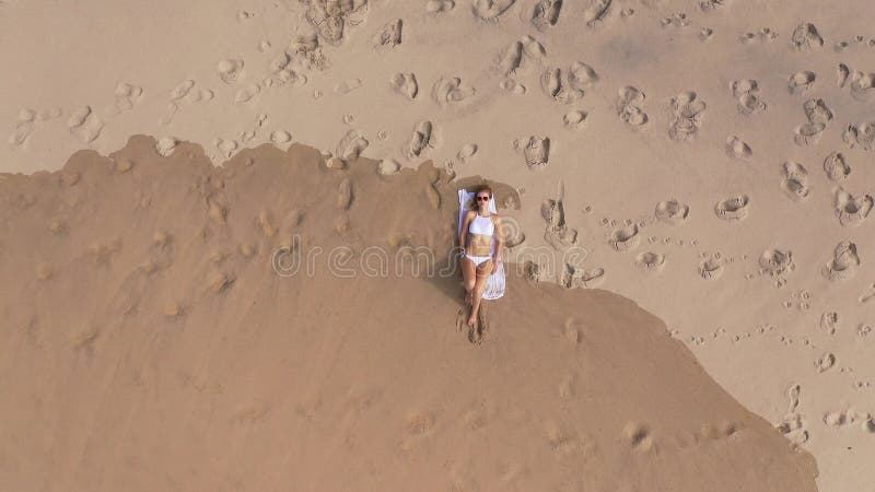 Beautiful Woman Relaxes On A Sandy Beach At The Ocean Stock Video
