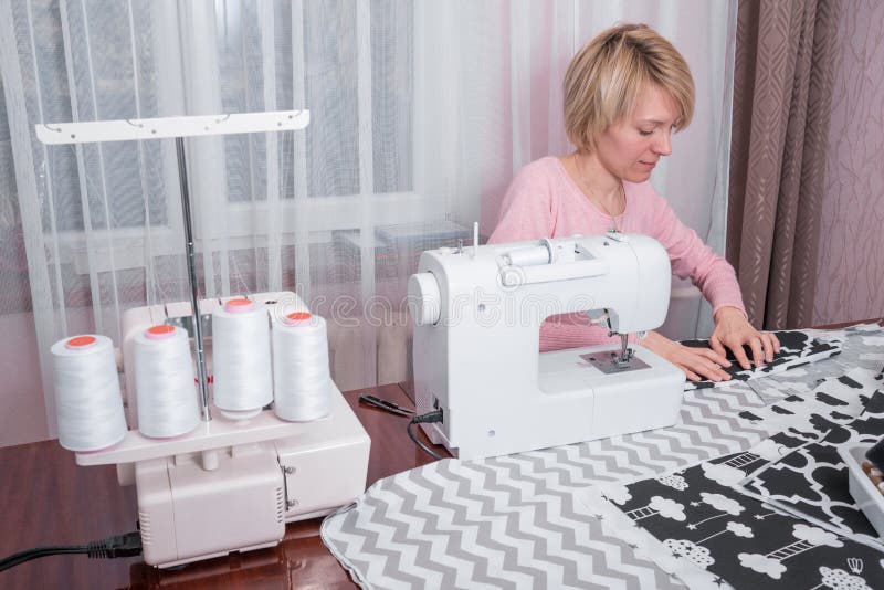 Beautiful Woman Seamstress Sew on the Sewing Machine Clothes. Stock ...