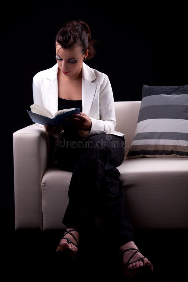 Beautiful Woman Seated on Couch Reading a Book Stock Photo - Image of ...