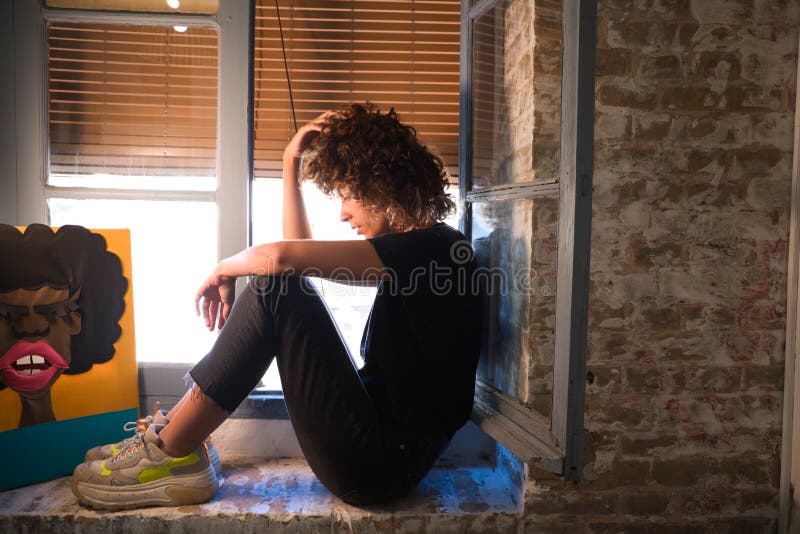 Beautiful Woman Sitting on the Edge of a Large Window in Her Studio ...