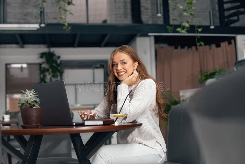 Beautiful Woman Sitting at the Table and Using Laptop Computer. Girl ...