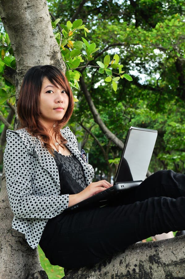 Beautiful Woman Sitting on Tree and Playing Laptop Stock Image - Image ...